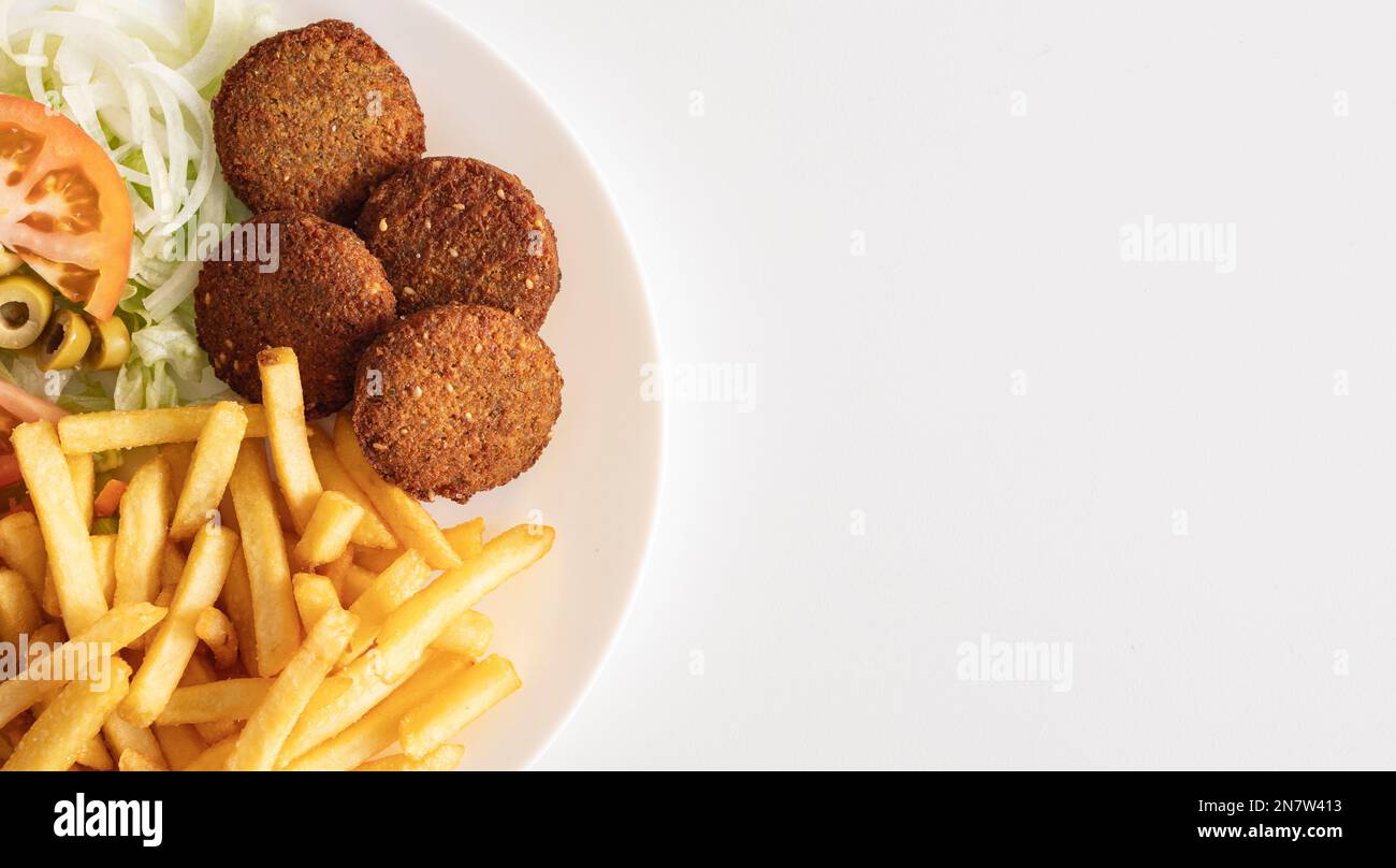 Falafel plate with chips and salad on white background with space for ...