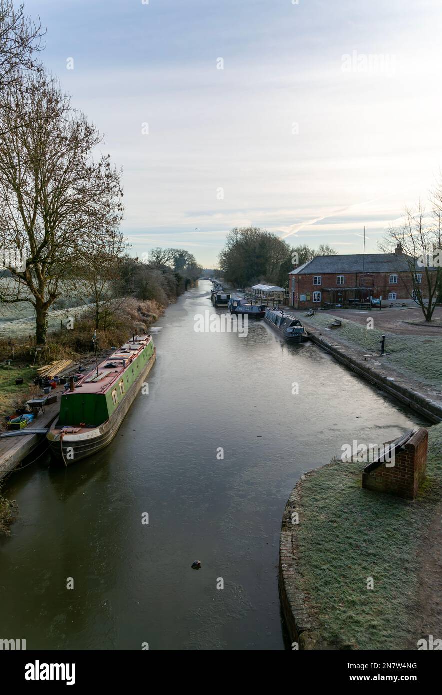 Narrow boats on frozen water of Kennet and Avon canal, Pewsey Wharf ...