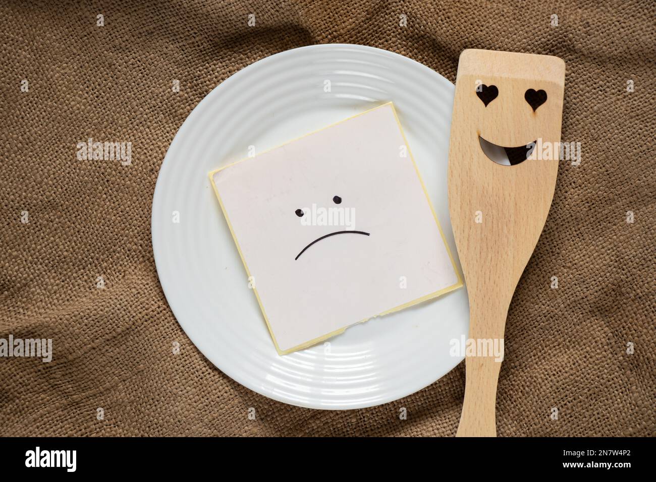 sad smiley lies on a sheet of paper on a plate next to a wooden spatula ...