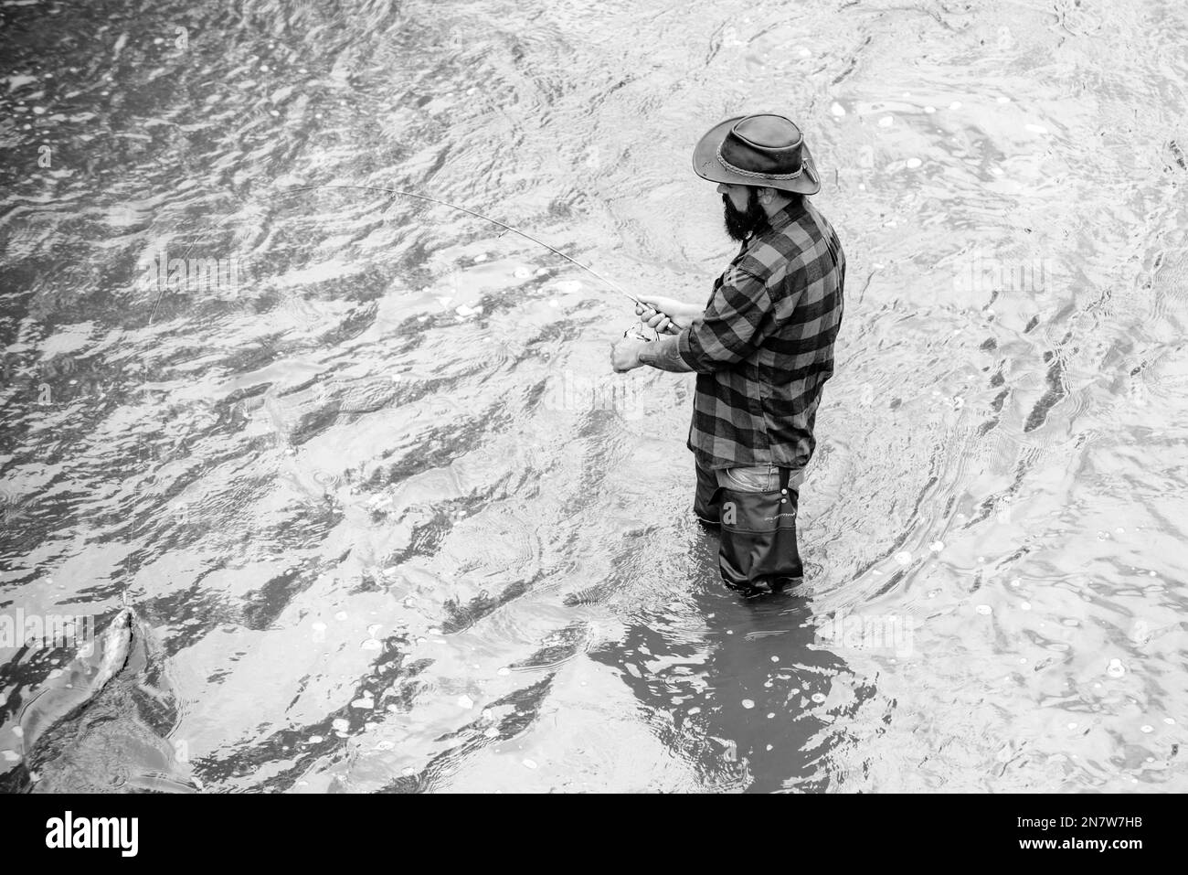 Man fishing in water. Bearded man catching fish. Young man fishing ...
