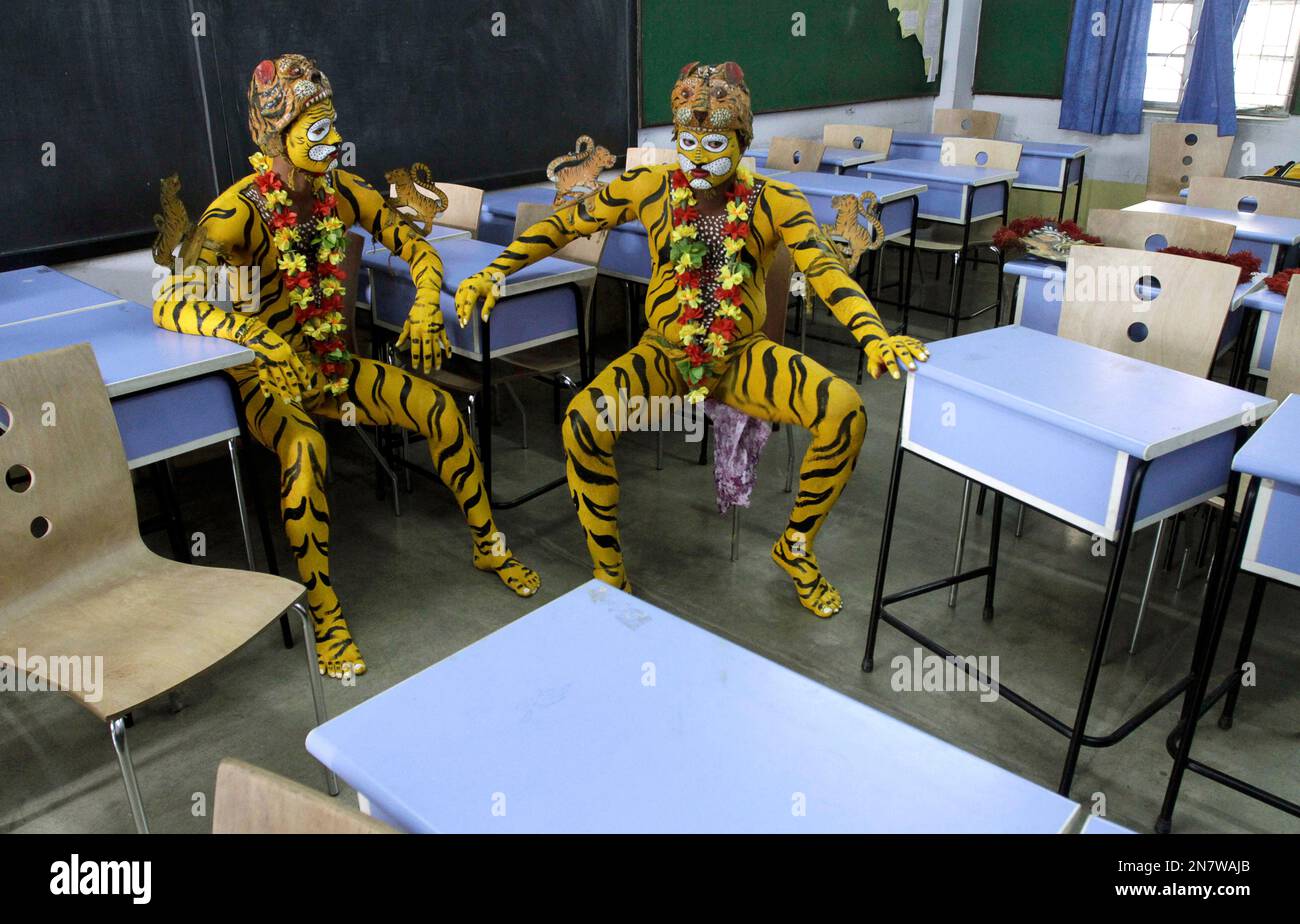 Traditional tiger dancers from Orissa state wait inside a classroom ...