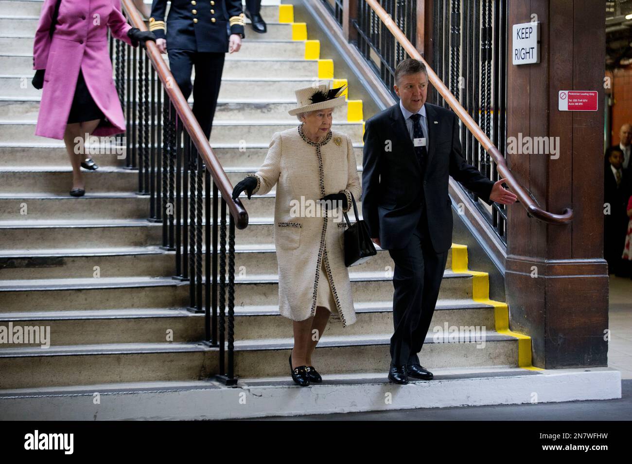 Britain's Queen Elizabeth II walks down stairs as she visits Baker ...