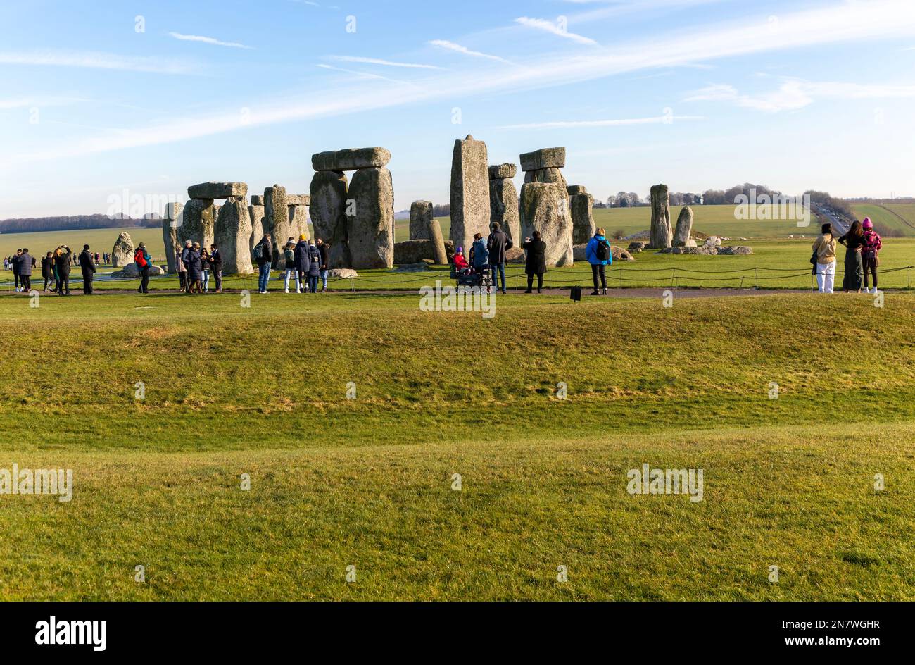 Tourists view standing stones of Neolithic henge, Stonehenge, Wiltshire ...