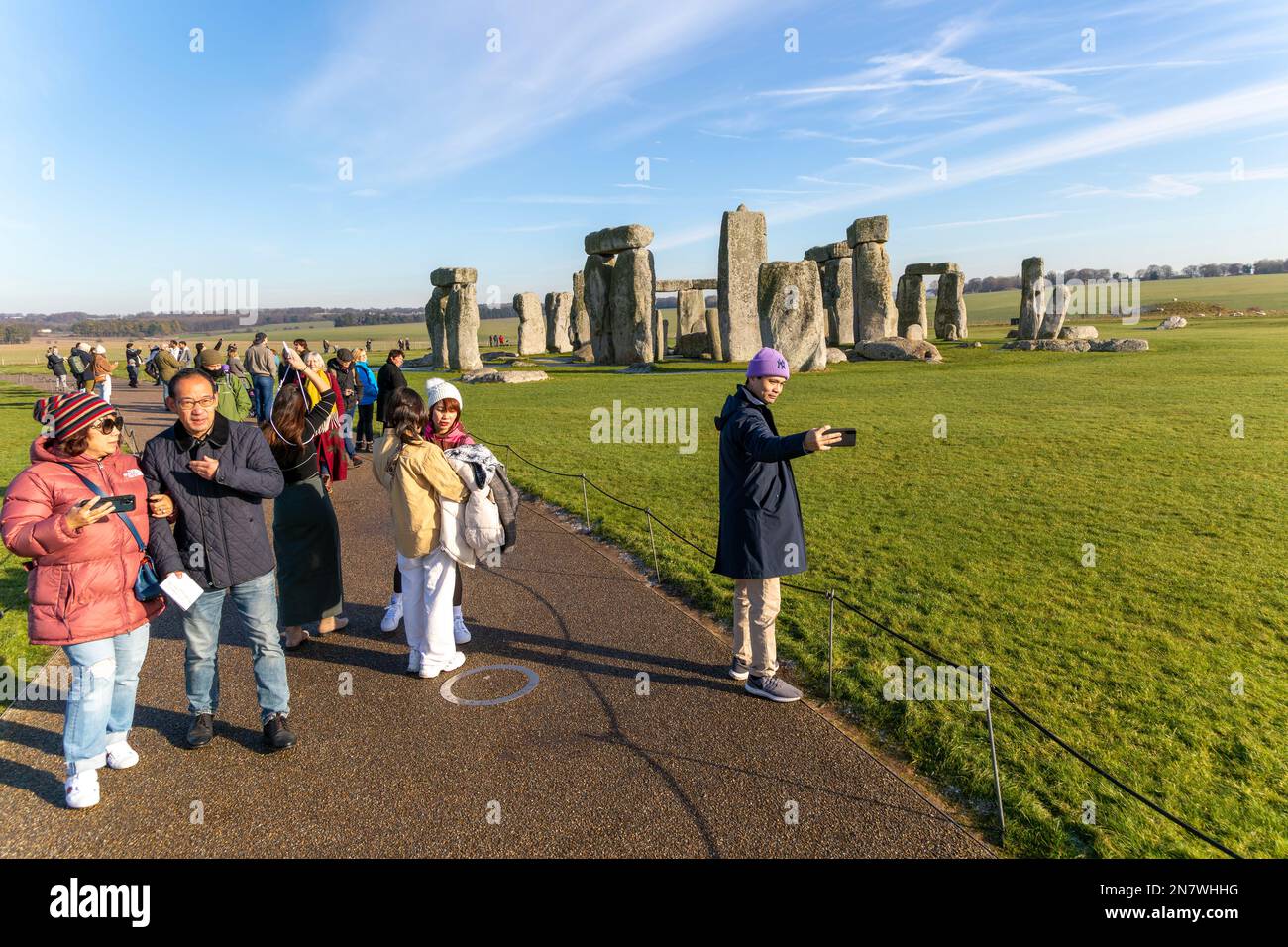 Asian tourists at standing stones of Neolithic henge, Stonehenge ...