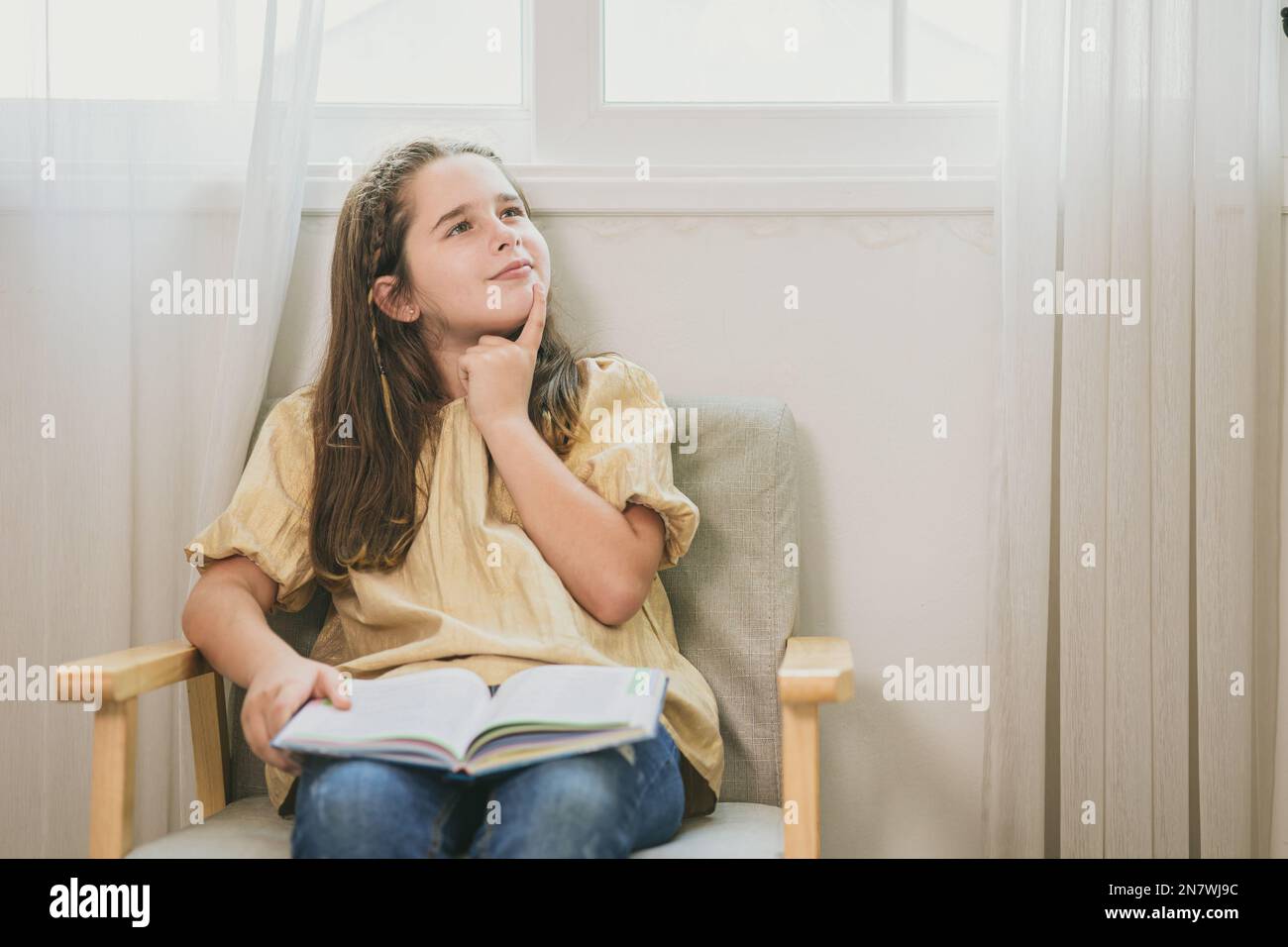 cute child girl reading a book and thinking new idea. bookworm nerdy ...