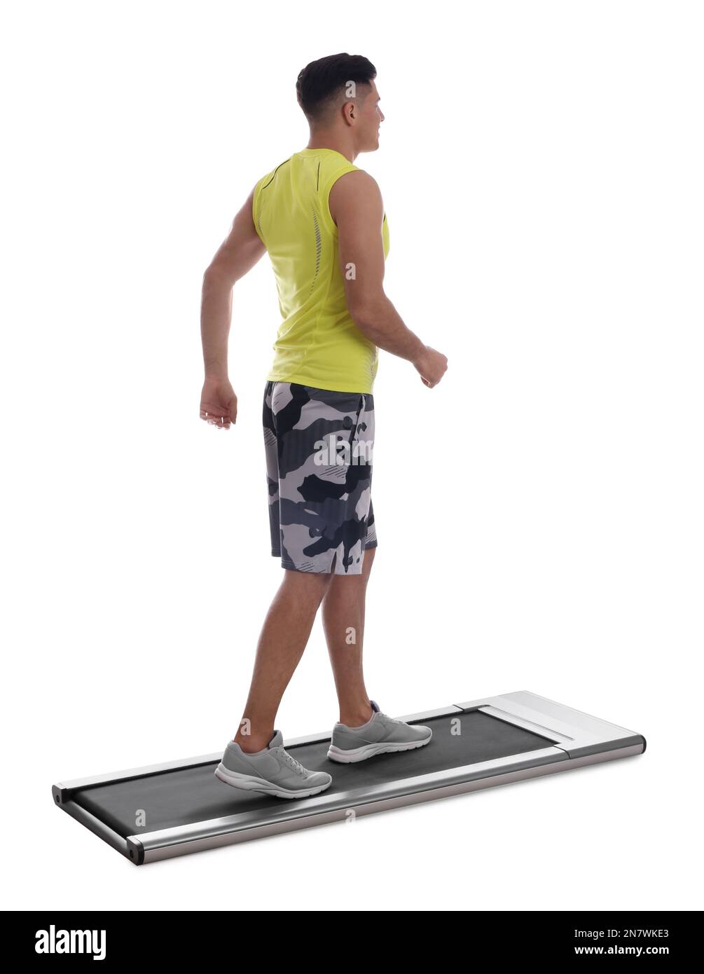 Sporty man using walking treadmill on white background Stock Photo - Alamy
