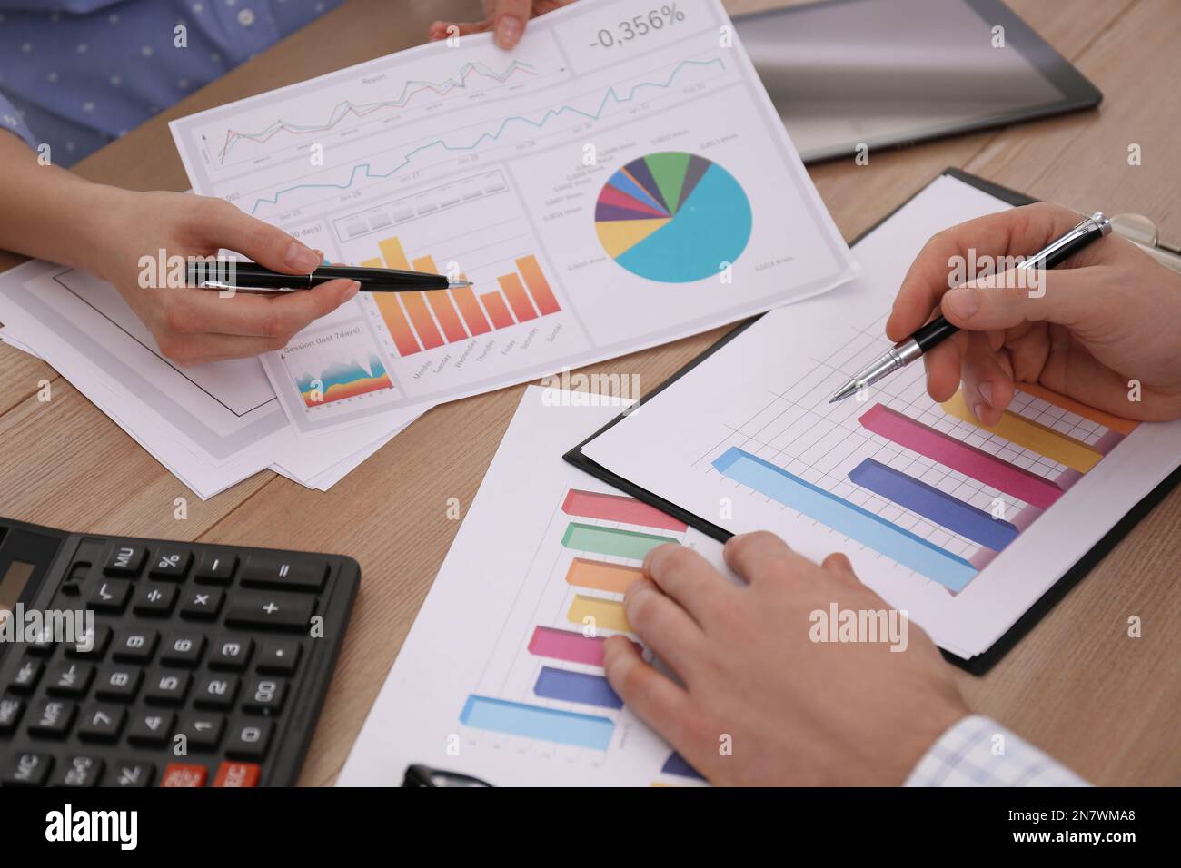 Business people working with charts and graphs at table in office ...