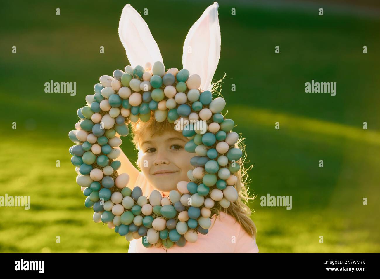 Child boy with easter eggs and bunny ears outdoor. Cute kid having ...