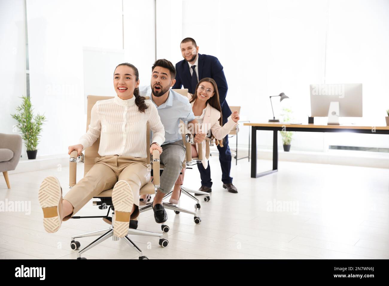 Office employees riding chairs at workplace. Space for text Stock Photo ...