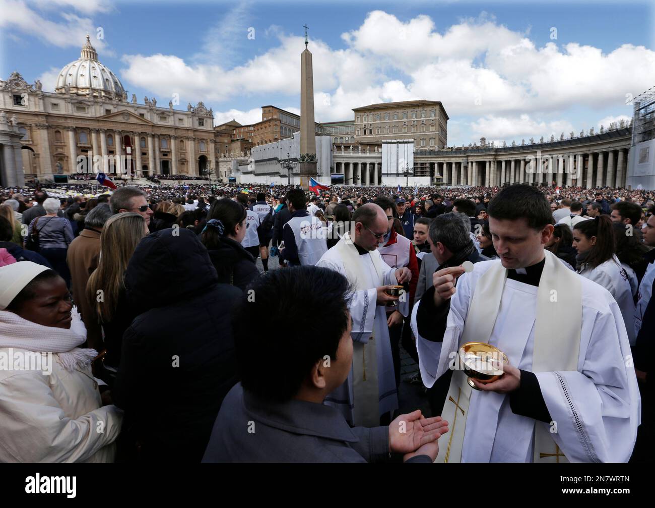 Priests deliver holy communion during the Mass for the inauguration of ...