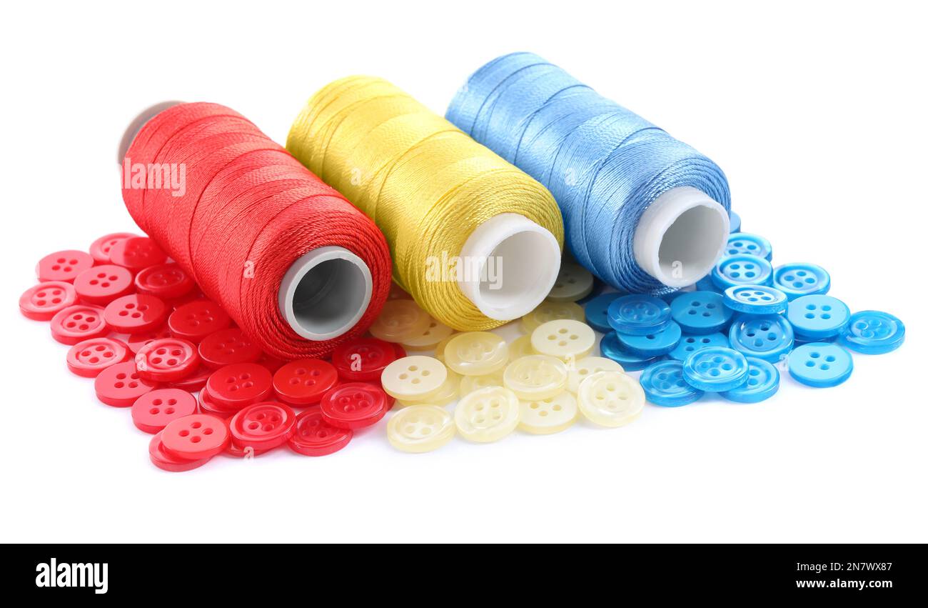 Set of colorful sewing threads and matching buttons on white background ...