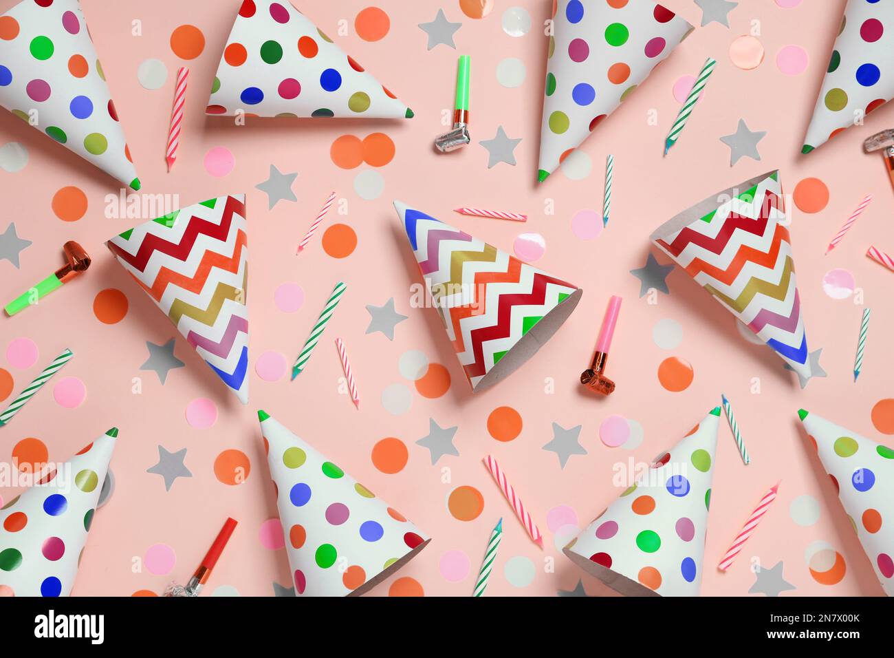 Flat lay composition with party cones and confetti on pink background ...