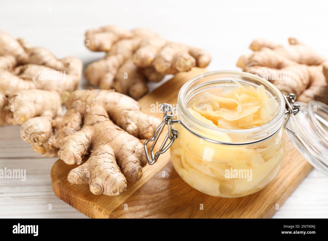 Spicy pickled ginger and root on white wooden table Stock Photo - Alamy