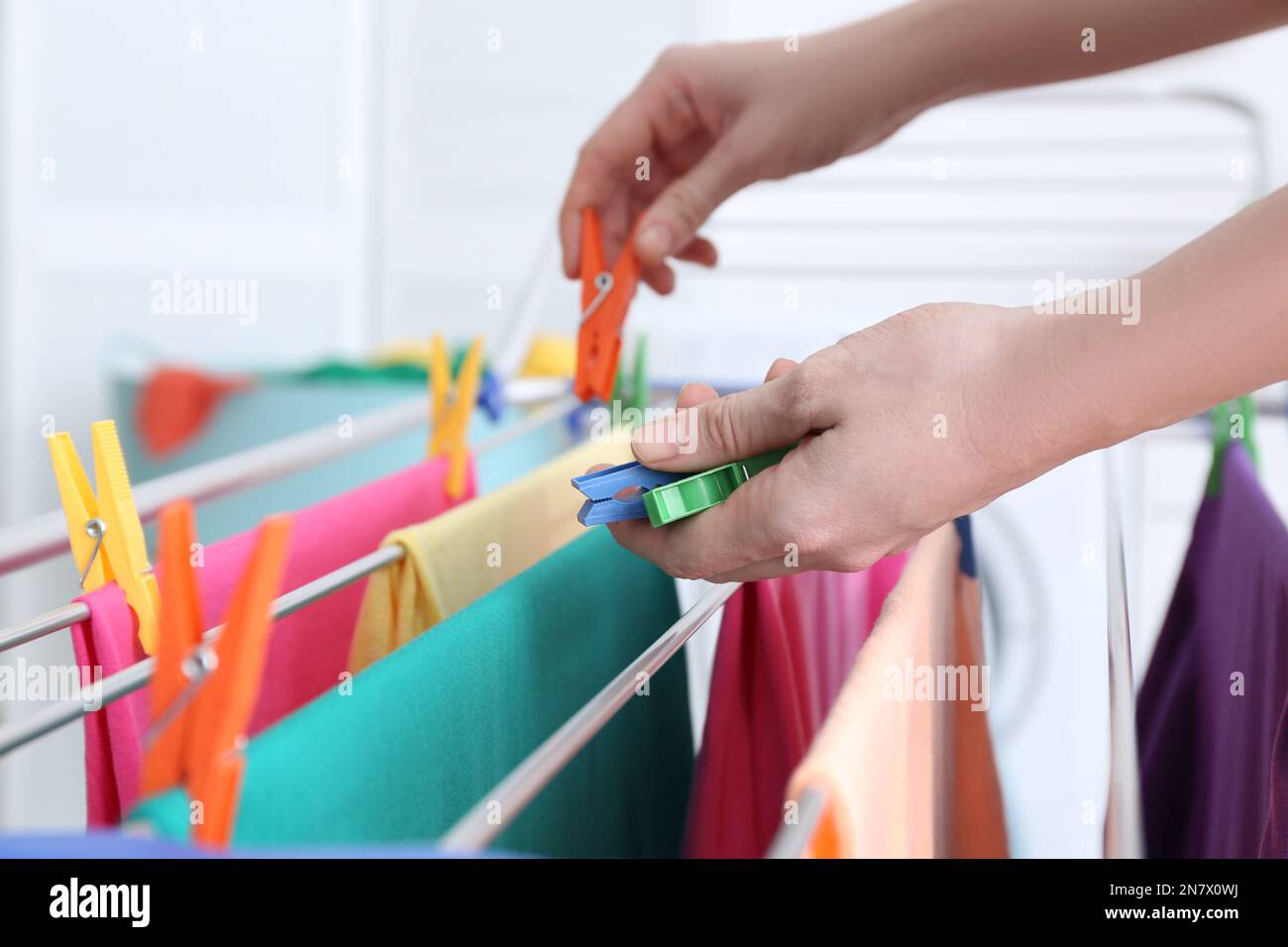 Woman hanging clean laundry on drying rack indoors, closeup Stock Photo ...