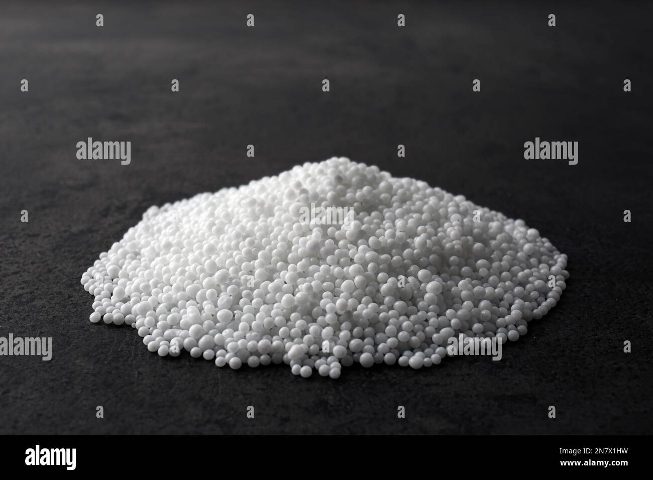 Pellets of ammonium nitrate on grey table. Mineral fertilizer Stock ...