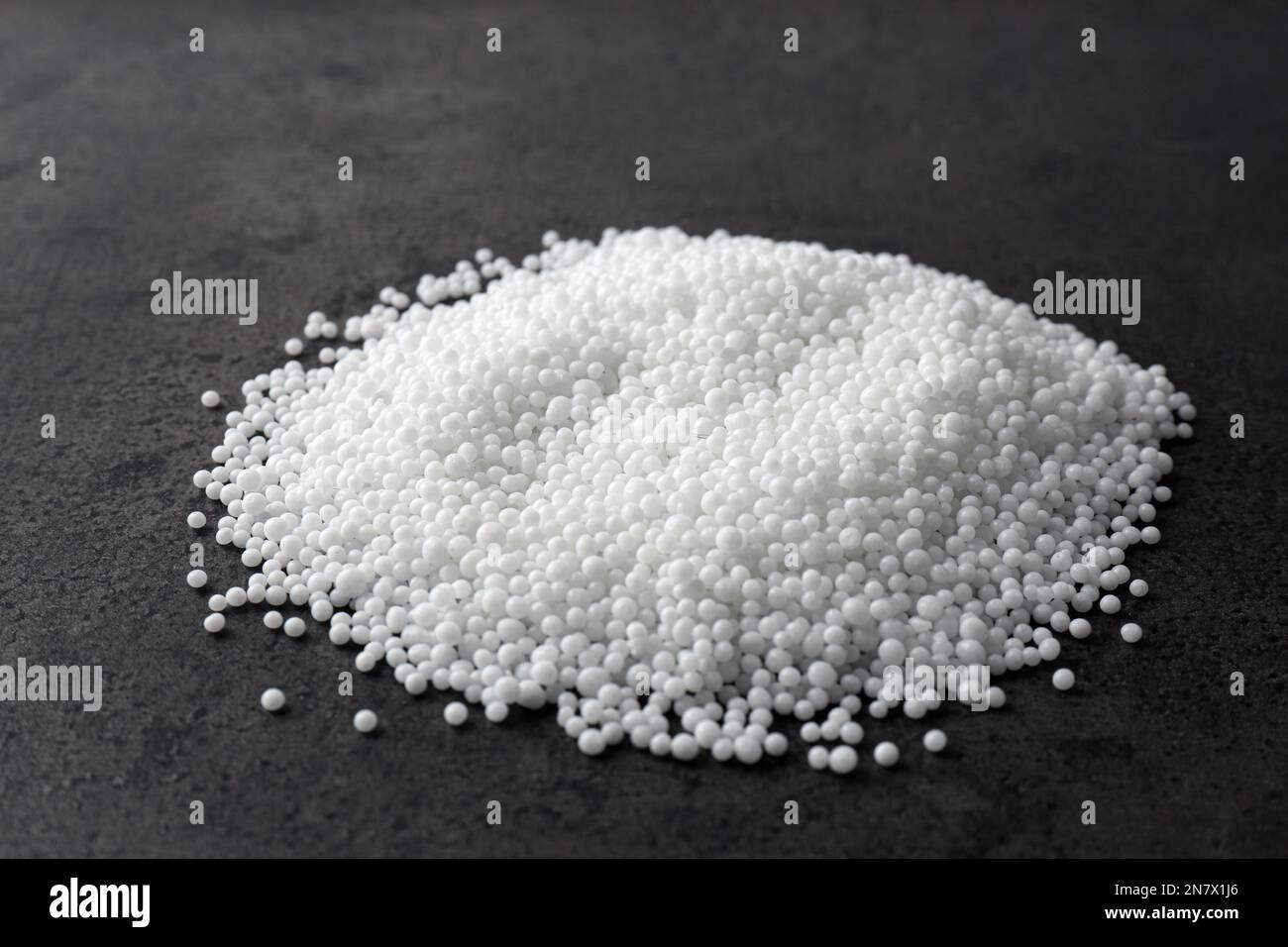 Pellets of ammonium nitrate on grey table. Mineral fertilizer Stock ...