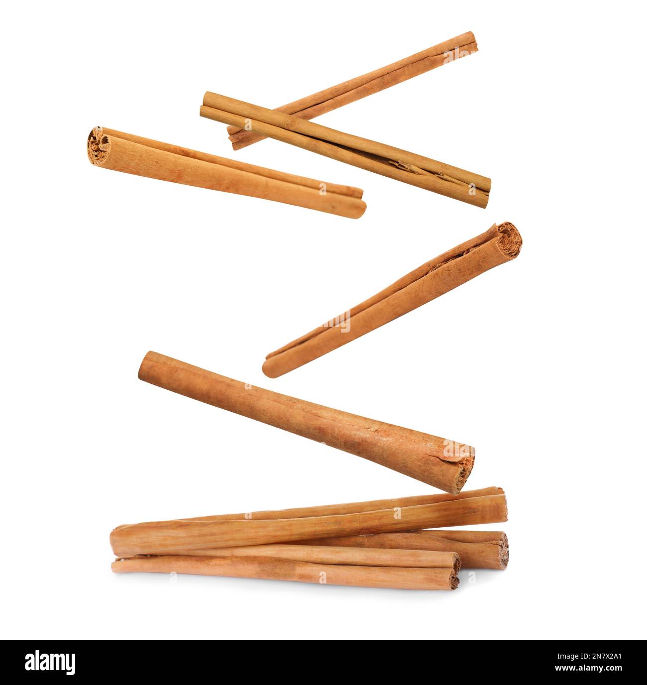 Aromatic cinnamon sticks falling on white background Stock Photo - Alamy