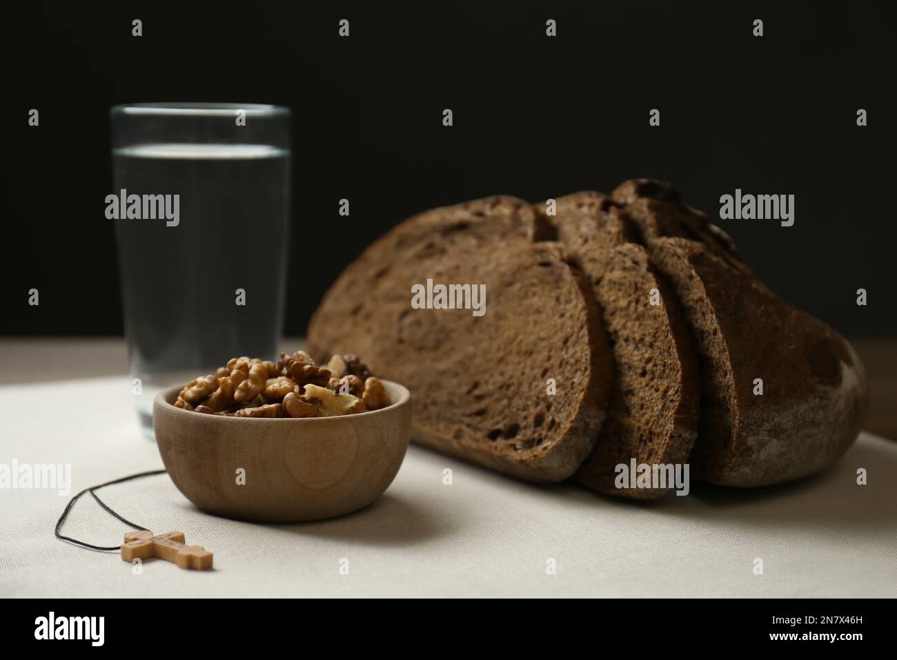 Bread, walnuts, water and crucifix on table. Great Lent season Stock ...