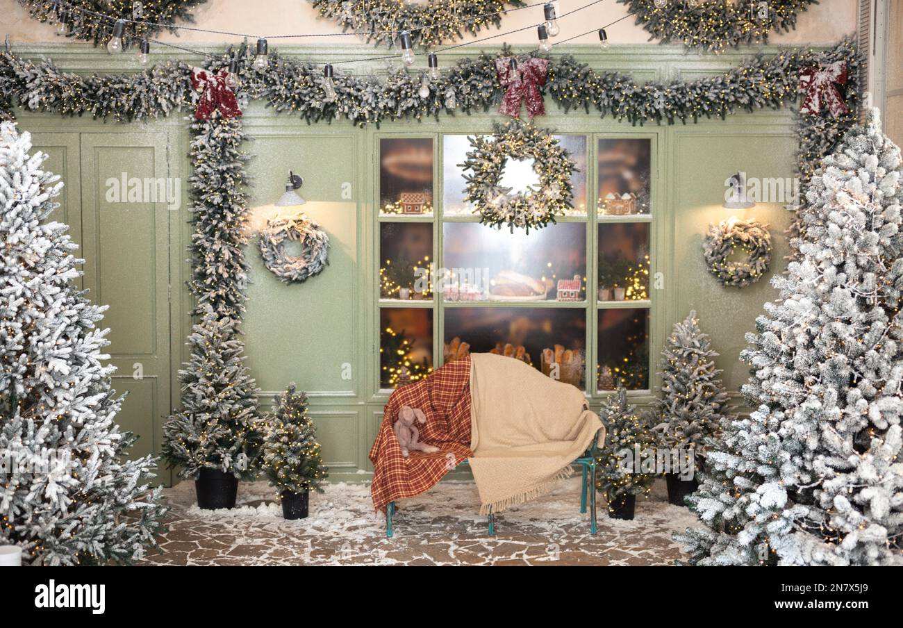 Christmas studio decorations outside in green tones with a bench and ...