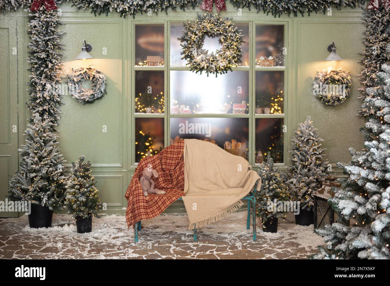 Christmas studio decorations outside in green tones with a bench and ...