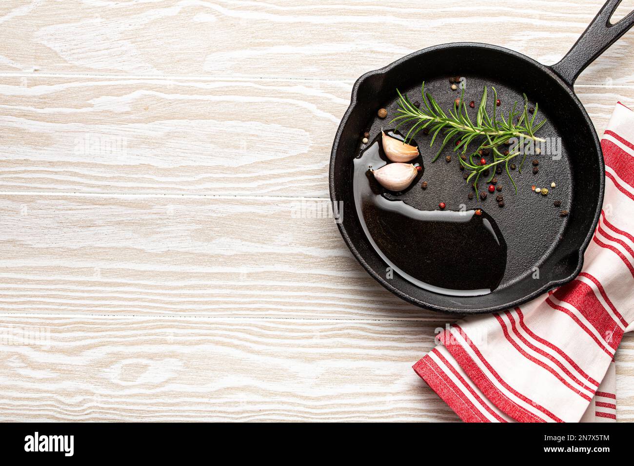 Black cast iron frying pan with ingredients for cooking: oil, fresh ...