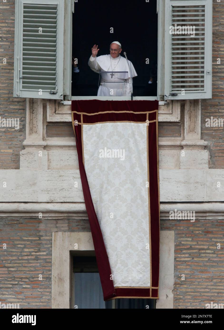 Pope Francis waves to the crowd in St. Peter's Square before saying the ...