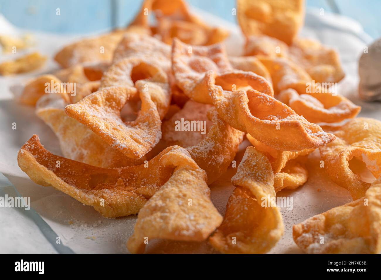 Sweet and golden angel wings with powdered sugar. Traditional snack in ...