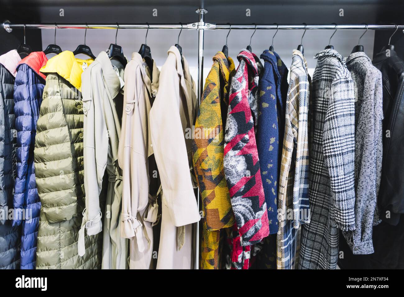 colorful collection women s coat hanging rack Stock Photo - Alamy