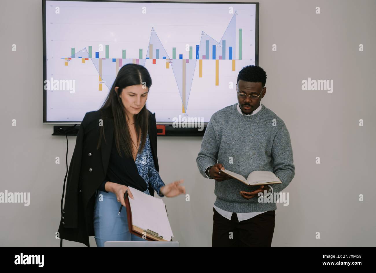 Black male and white female people giving presentation to a group of ...