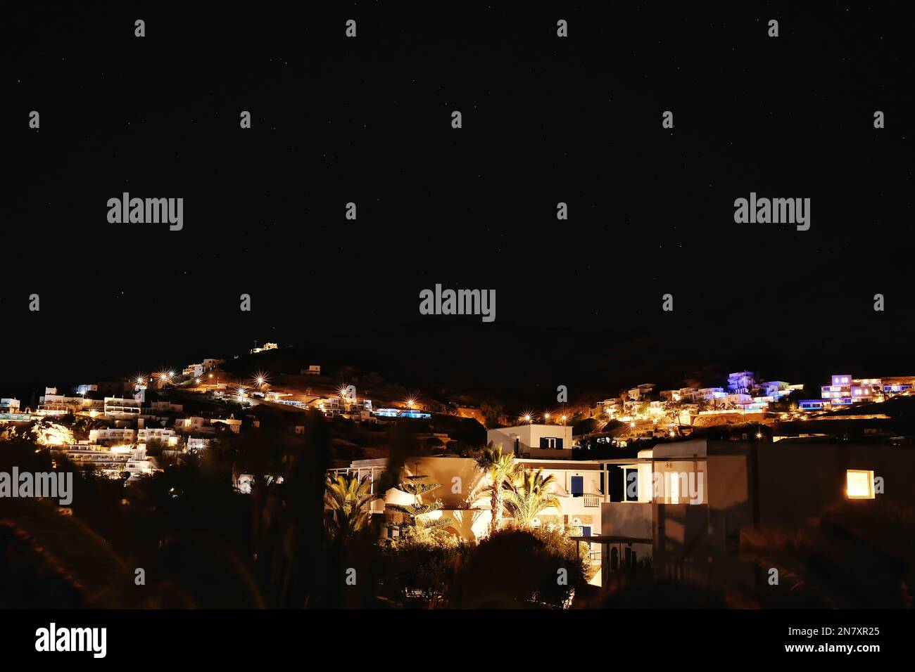 View of various illuminated beautiful hotels and stars in the night sky ...