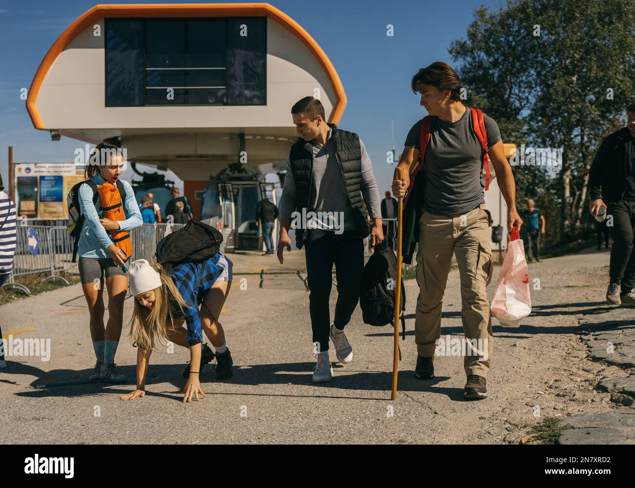 Blonde girl falling on the ground while her friends are looking at her ...