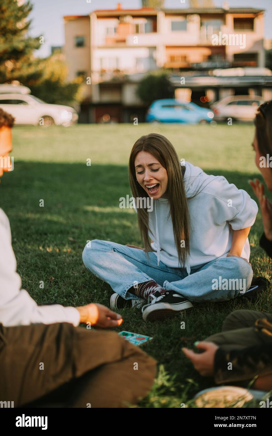 Beautiful blonde girl laughing with her friends while playing ludo ...