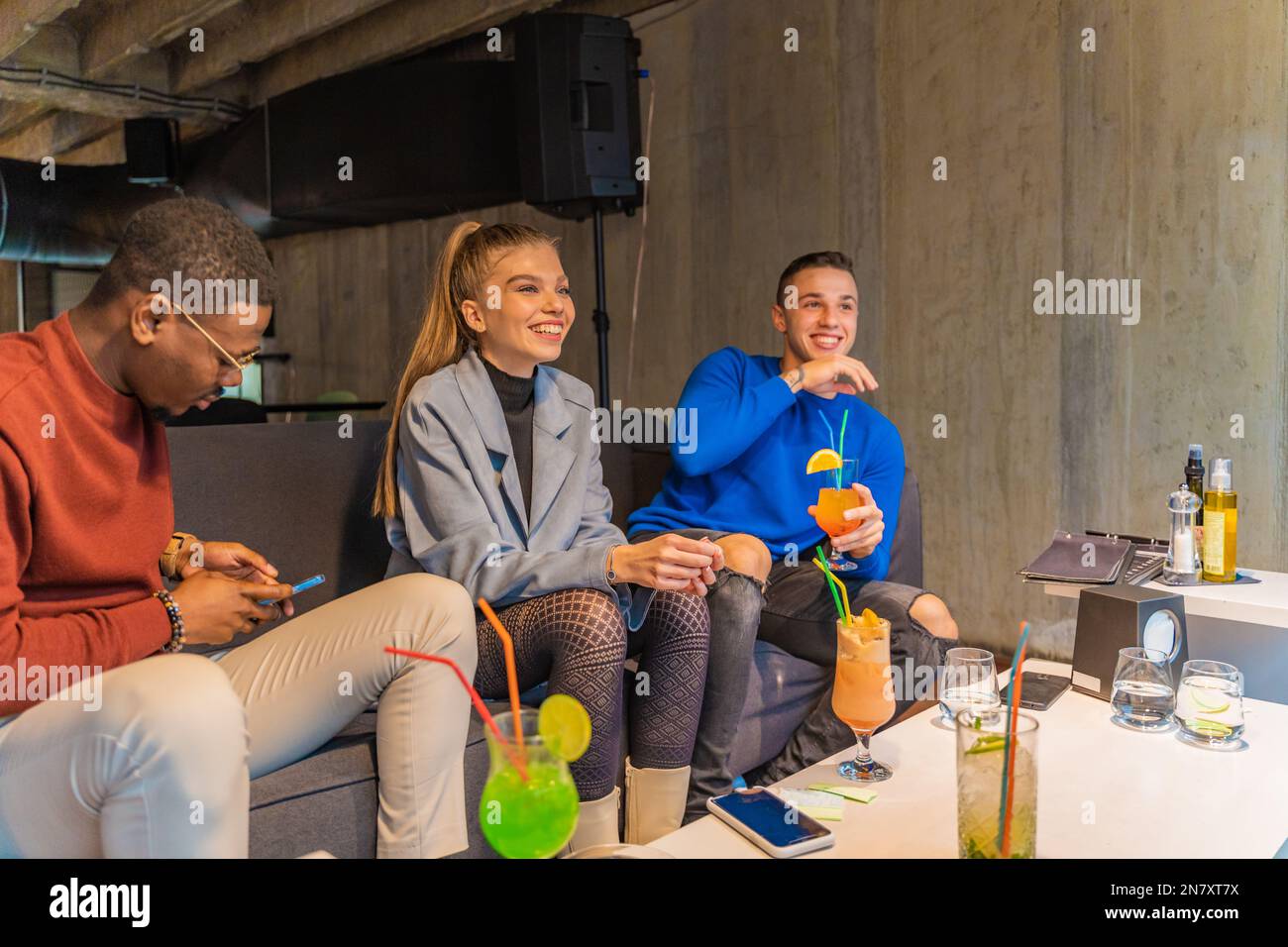 Three friends are laughing together while enjoying their time Stock ...