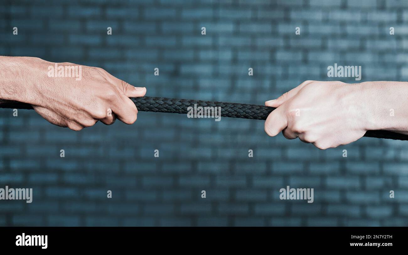 Pull like your life depends on it. two people pulling a rope in tug of ...