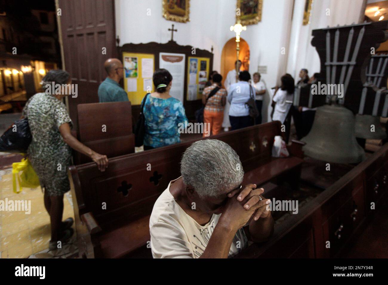 A woman prays inside La Merced church in Panama City, Wednesday, March ...