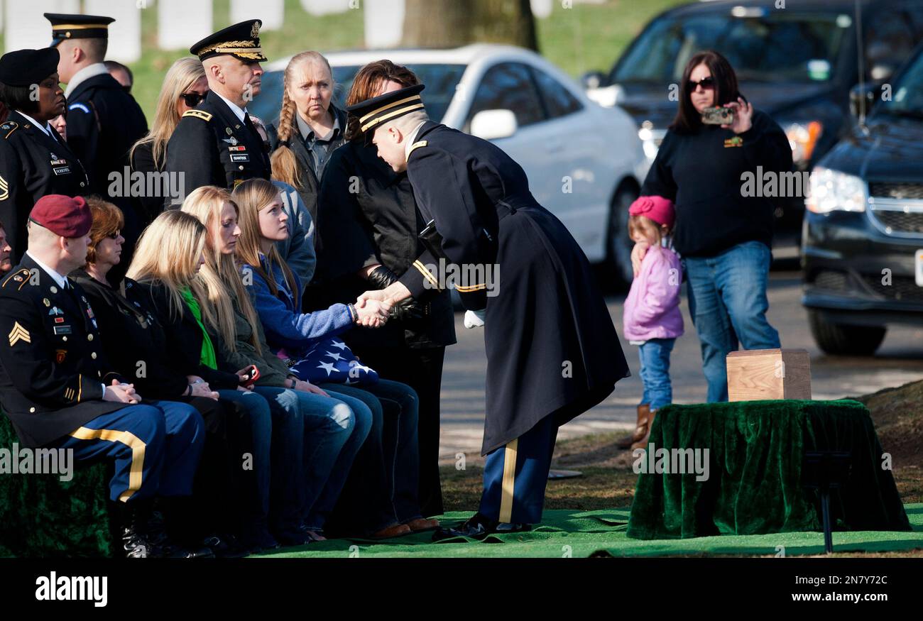 Army Chaplain Capt. Ronny Fisher, center, holds the hand of Ashley ...