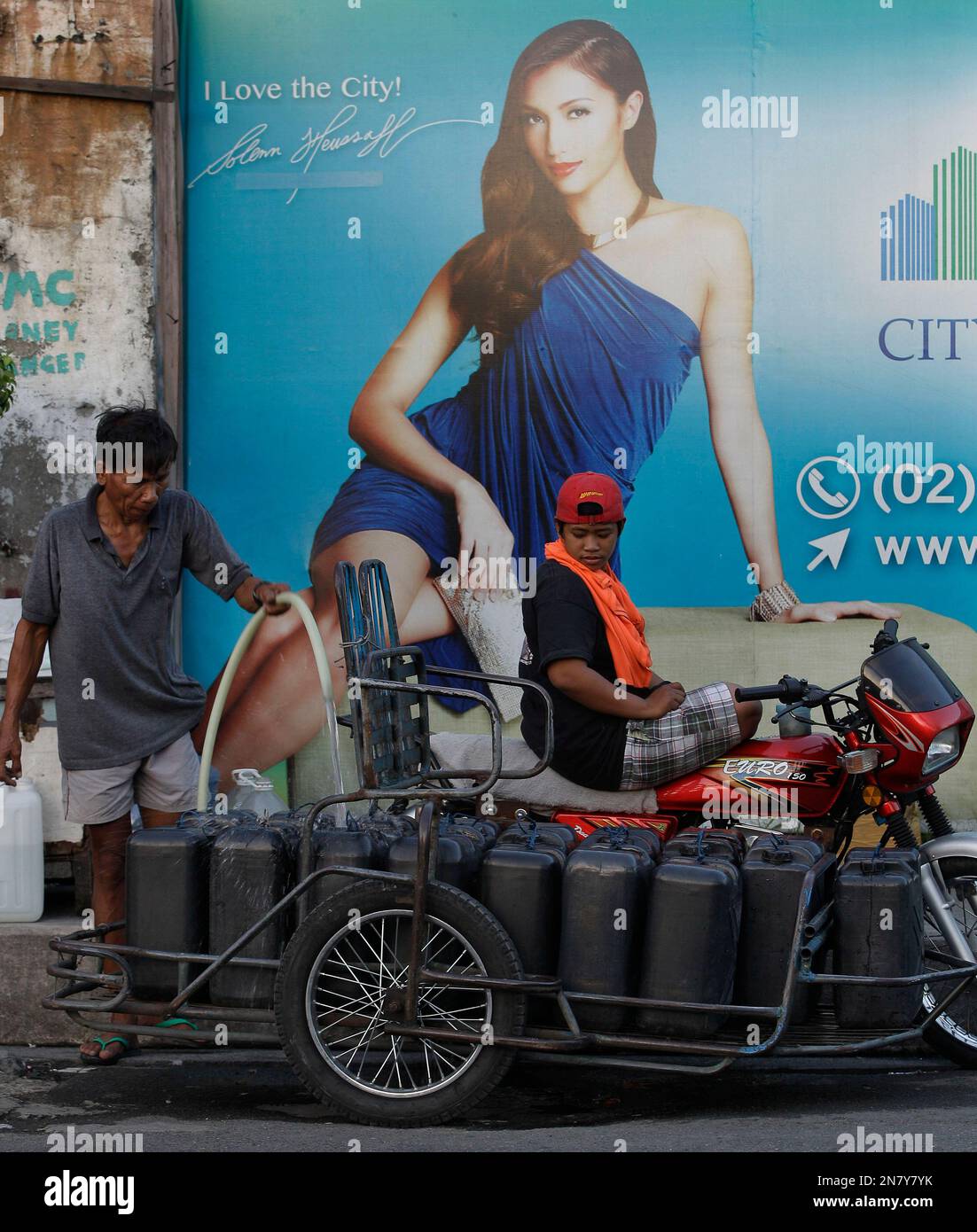 In this March 12, 2013 photo, a Filipino man fills up containers with ...