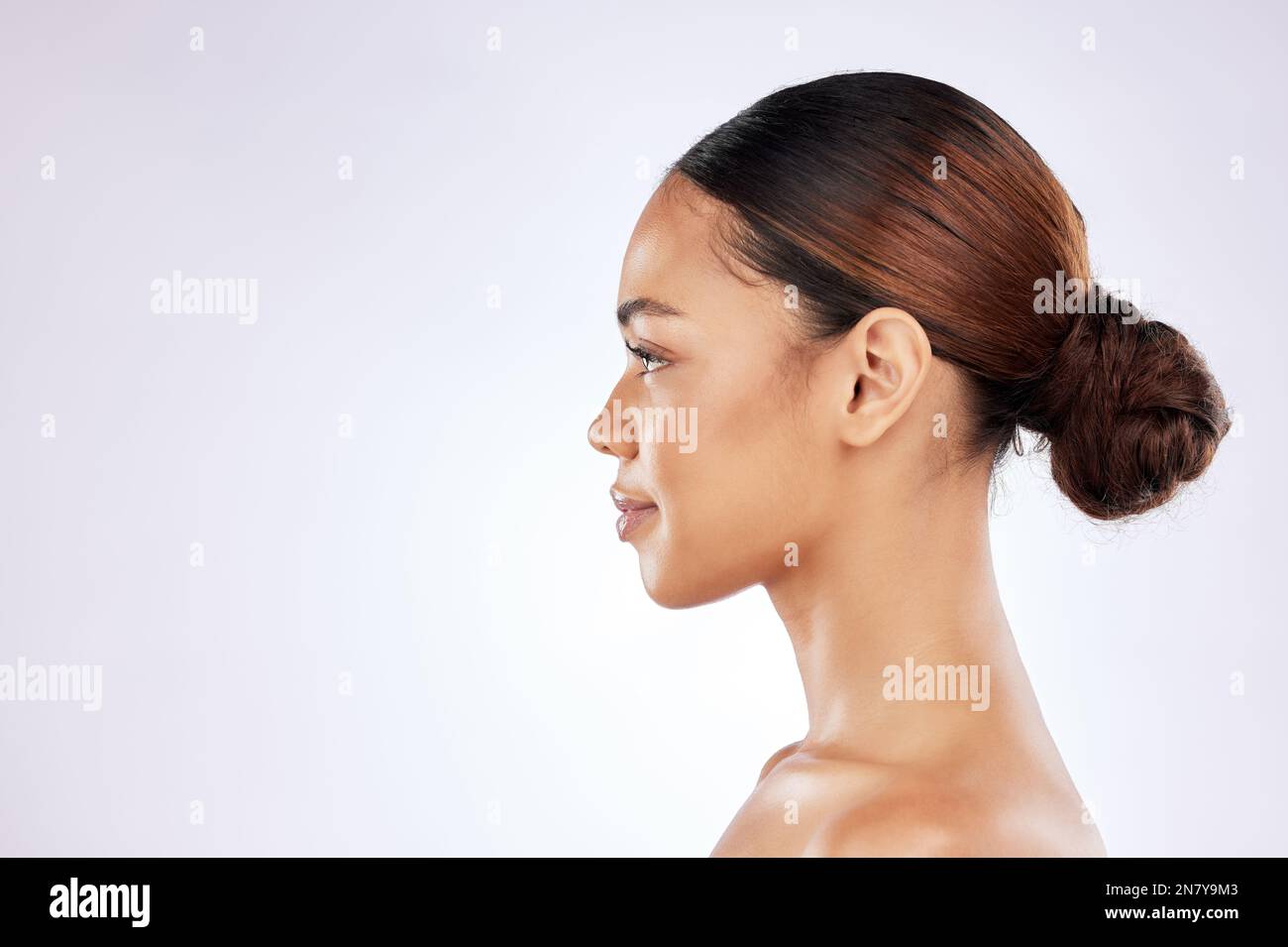 Giving you my best side. a happy young woman posing against a studio ...