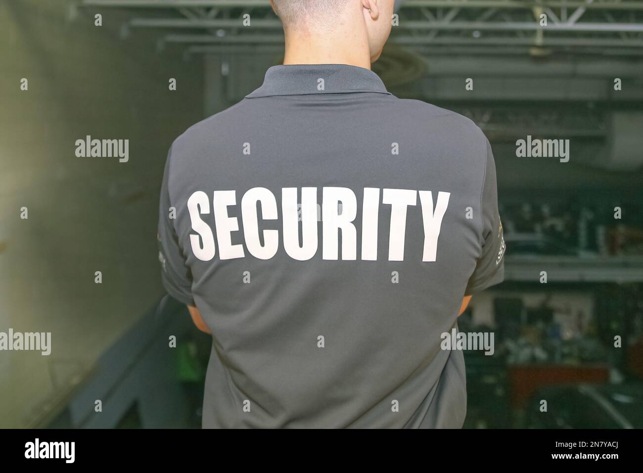 A back of a security guard patrolling inside a warehouse at night Stock ...