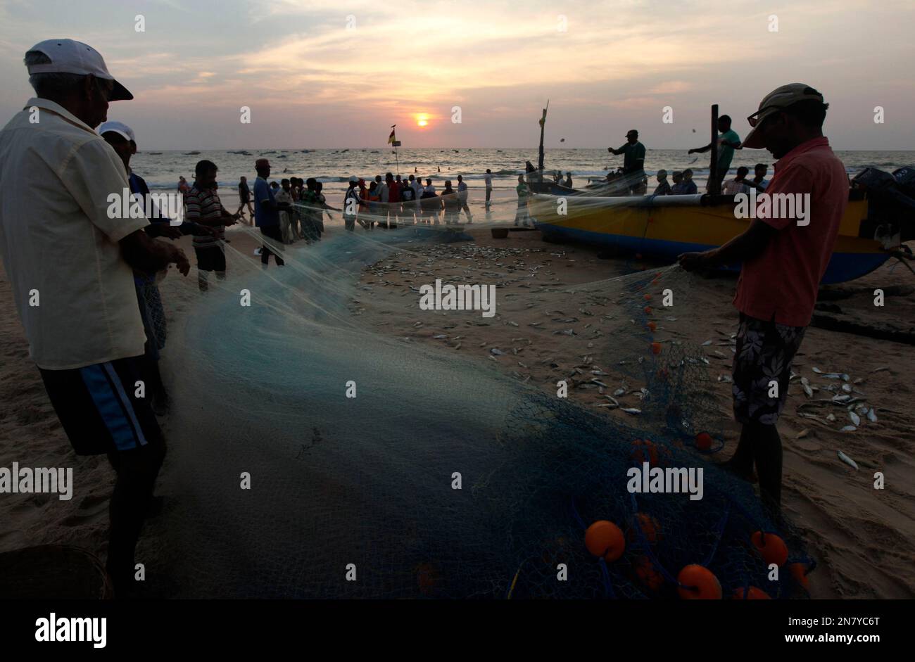 In this Monday, March 11, 2013 photograph, Indian fishermen pick fish ...