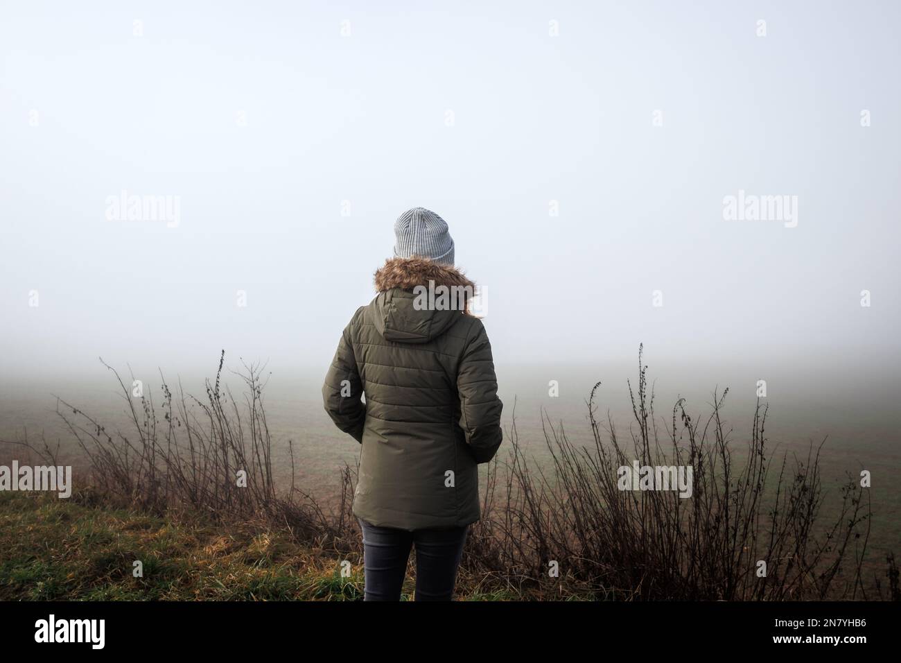 Lost female person in fog. Lonely woman standing in empty misty ...