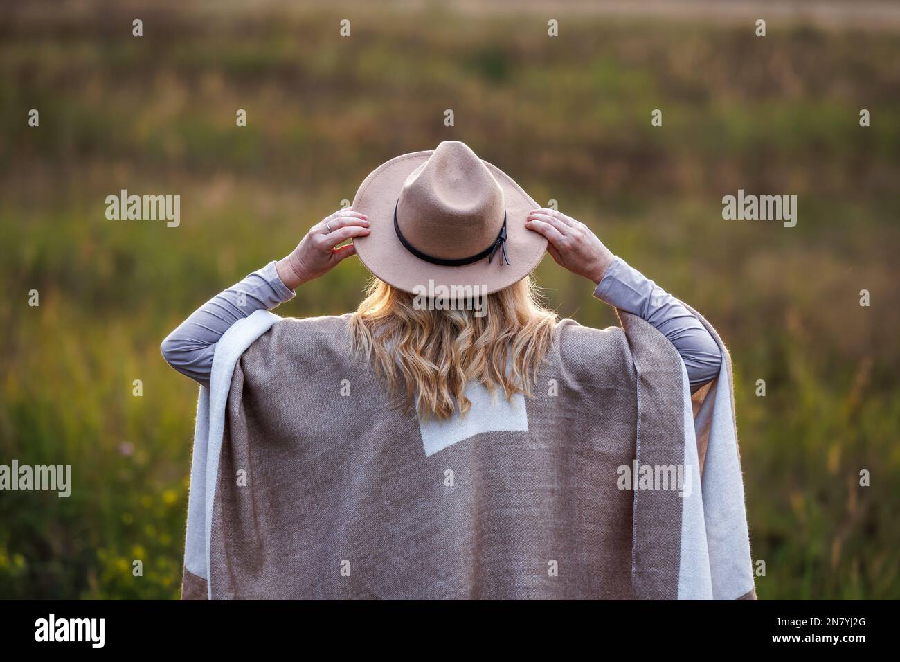 Woman wearing poncho and cowboy hat outdoors. Boho fashion style Stock ...