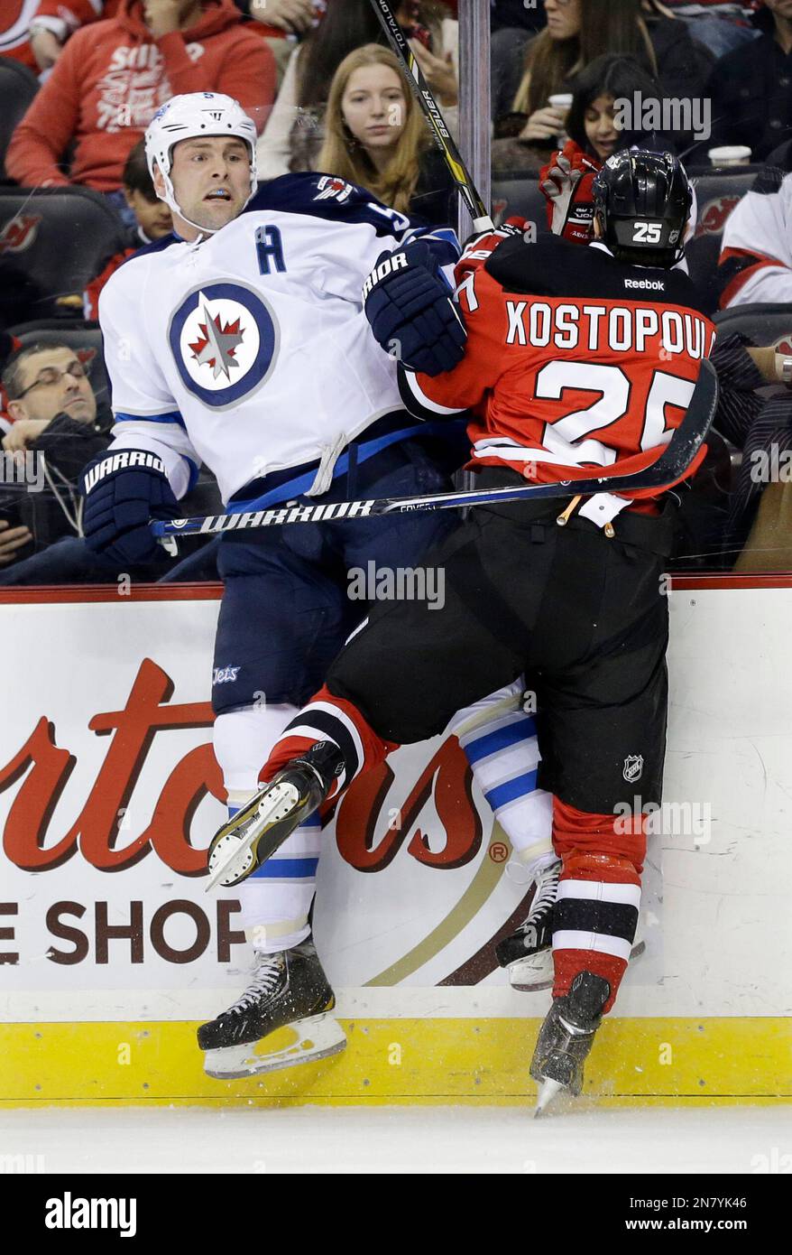Winnipeg Jets' Mark Stuart (5) and New Jersey Devils' Tom Kostopoulos ...
