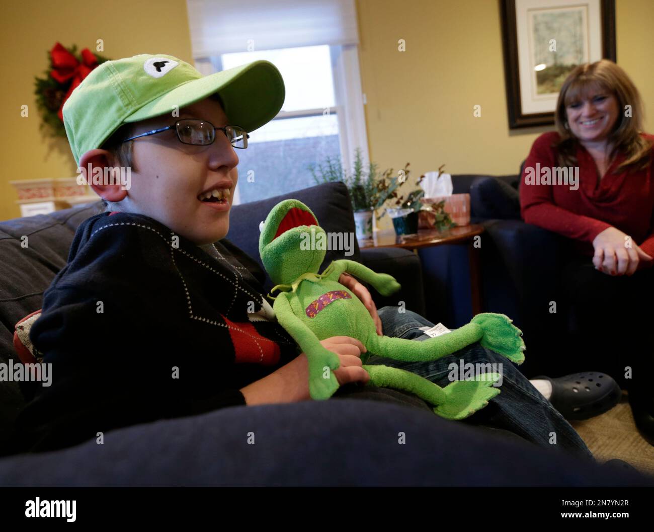 Connor Troy, 12, plays with his Kermit the Frog toy as his mother Kerry ...