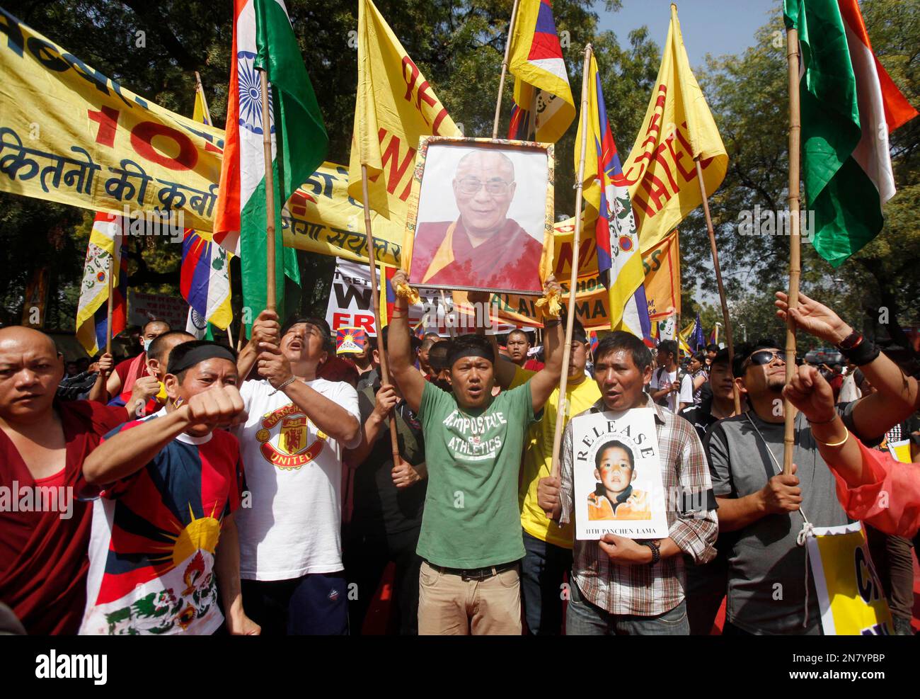 Tibetan Exiles in India carry an Indian flag, third left along with ...
