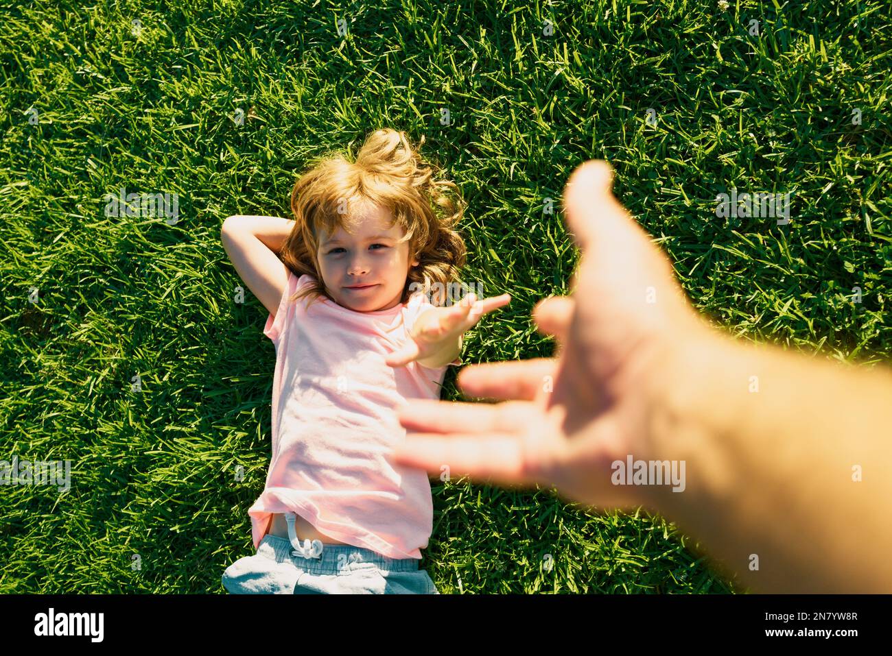 Kid pull father hand. Follow me, hand-in-hand walking on bright sunny ...