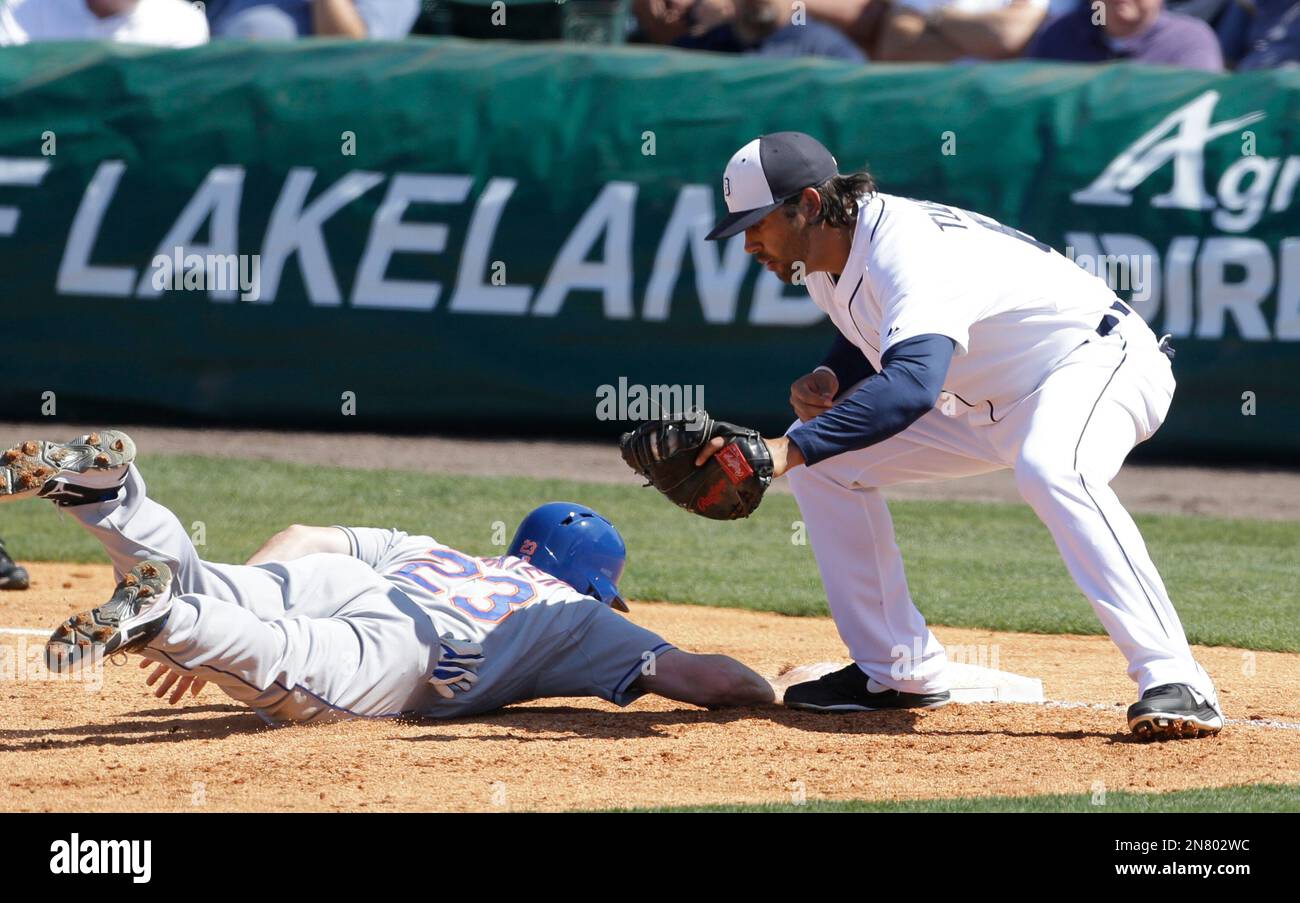 New York Mets runner Mike Baxter jumps back to first under the tag of ...