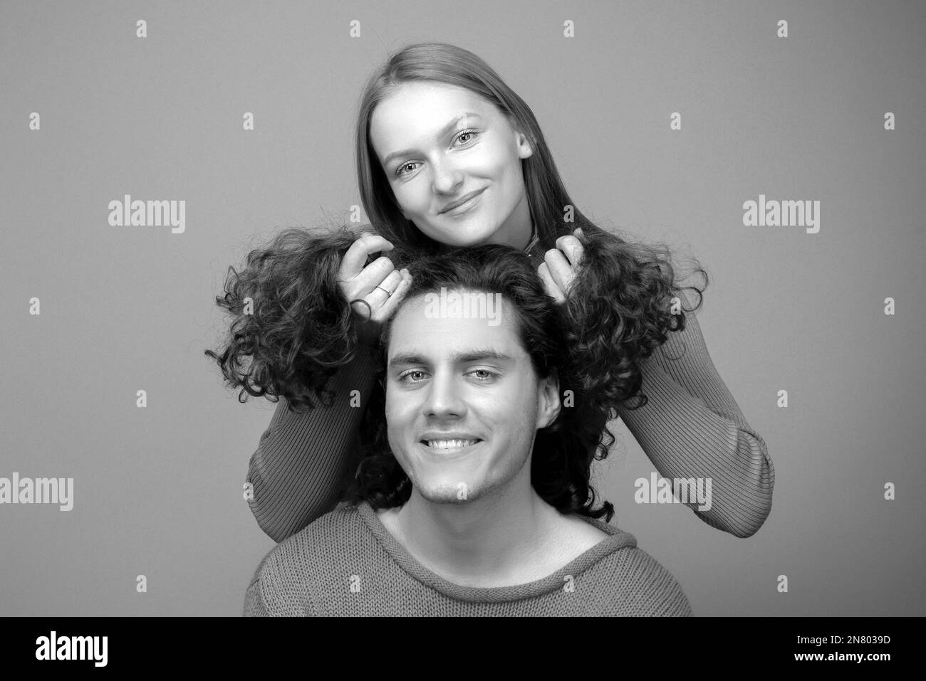 Handsome man with long wavy hair and his cute girlfriend. Beautiful ...