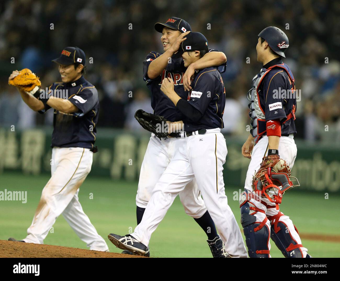 Japan's captain Shinnosuke Abe, second from left, holds closer Toshiya ...