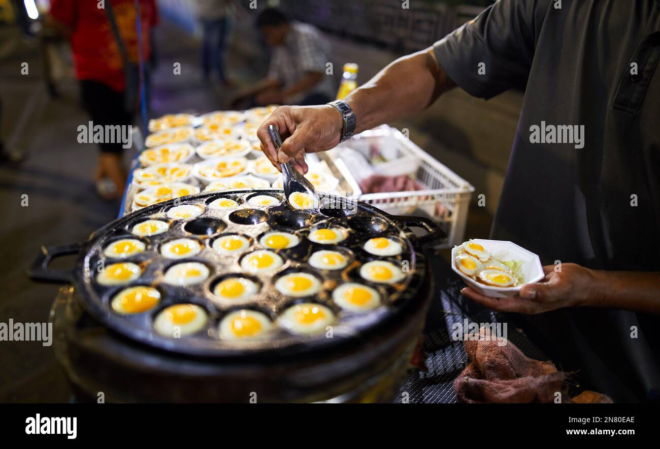 Street food of Thai fried eggs at big pan at night market at the ...